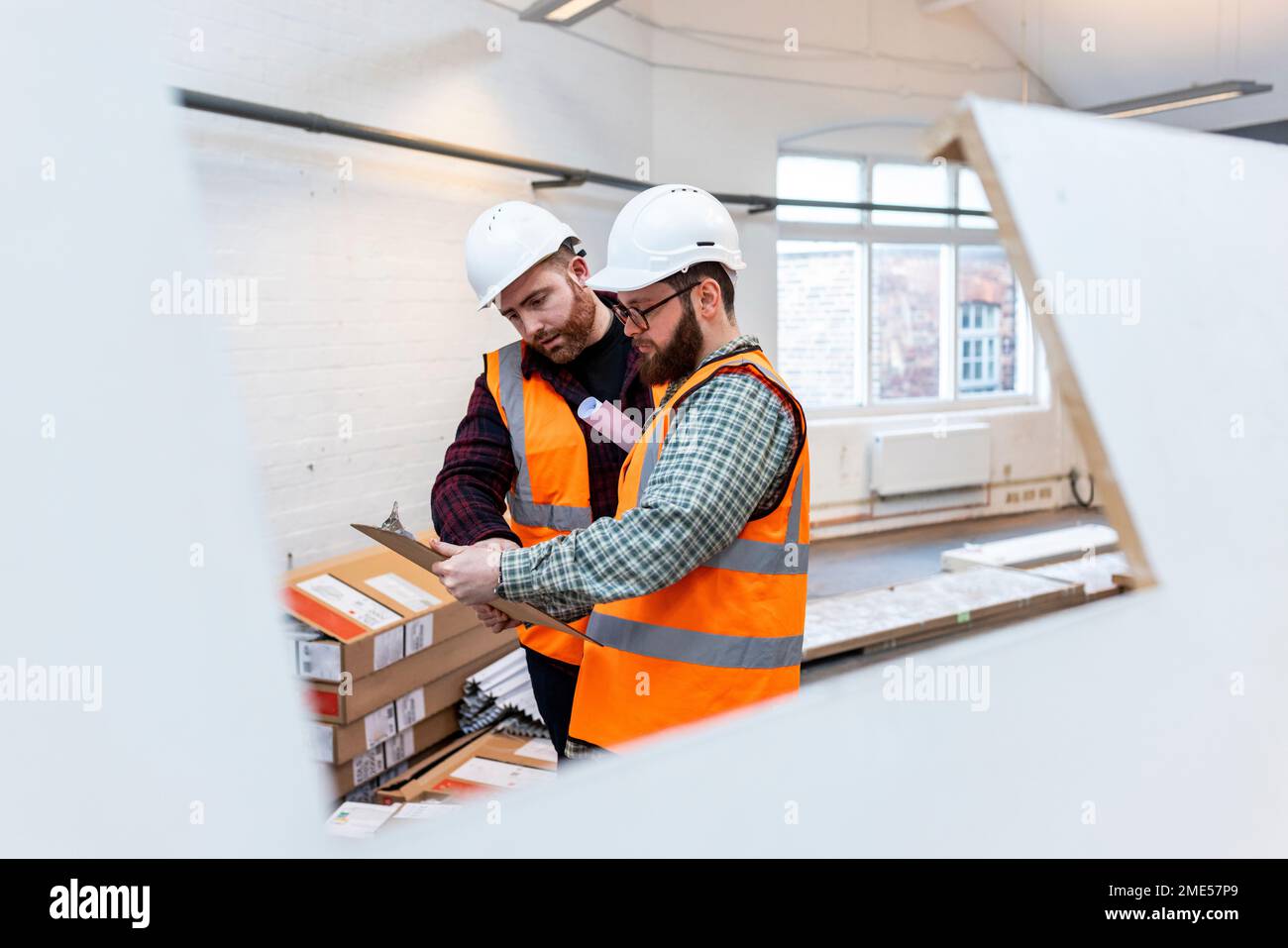 Engineers discussing over document at construction site Stock Photo - Alamy