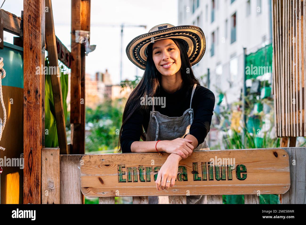 Happy young woman standing behind signboard in urban garden Stock Photo ...