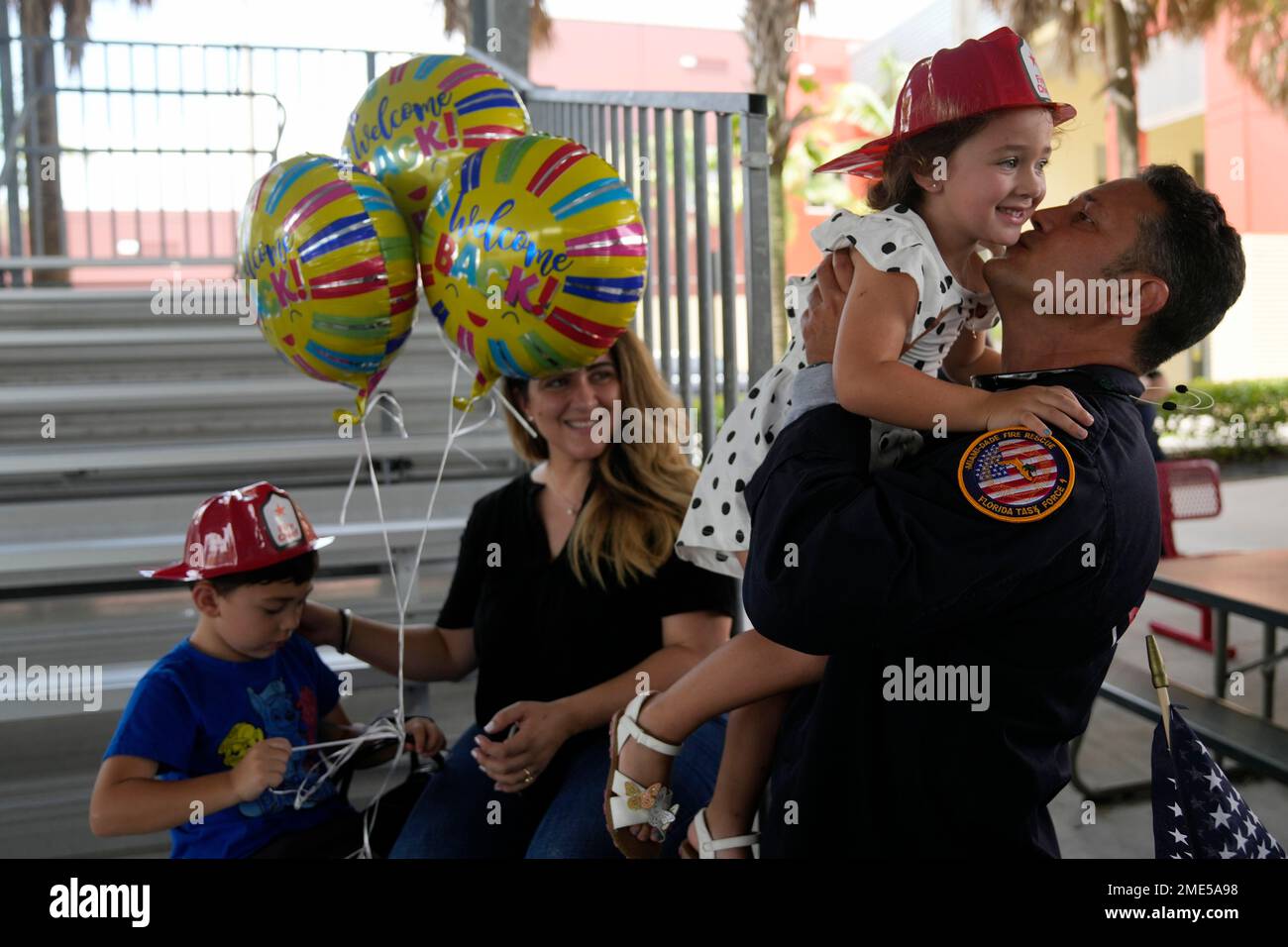 Capt. Eric Hernandez lifts up his daughter Isabella, 3, as his wife ...