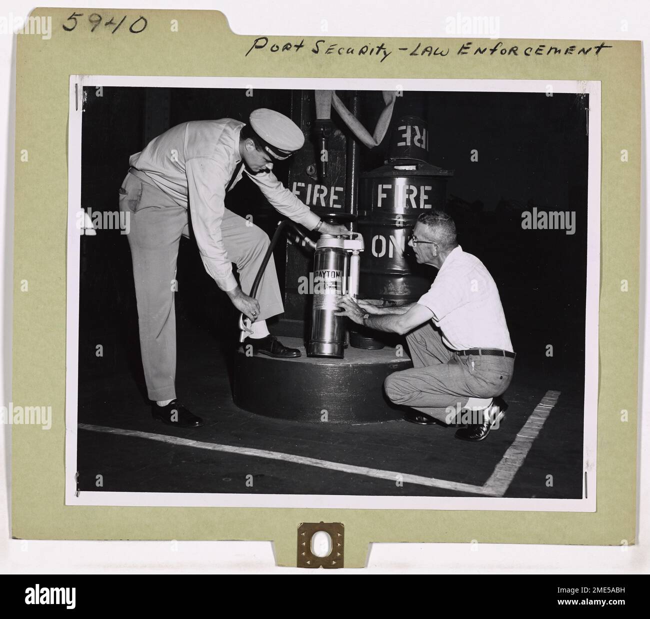 A Coast Guard inspector is shown examining firefighting equipment at a ...