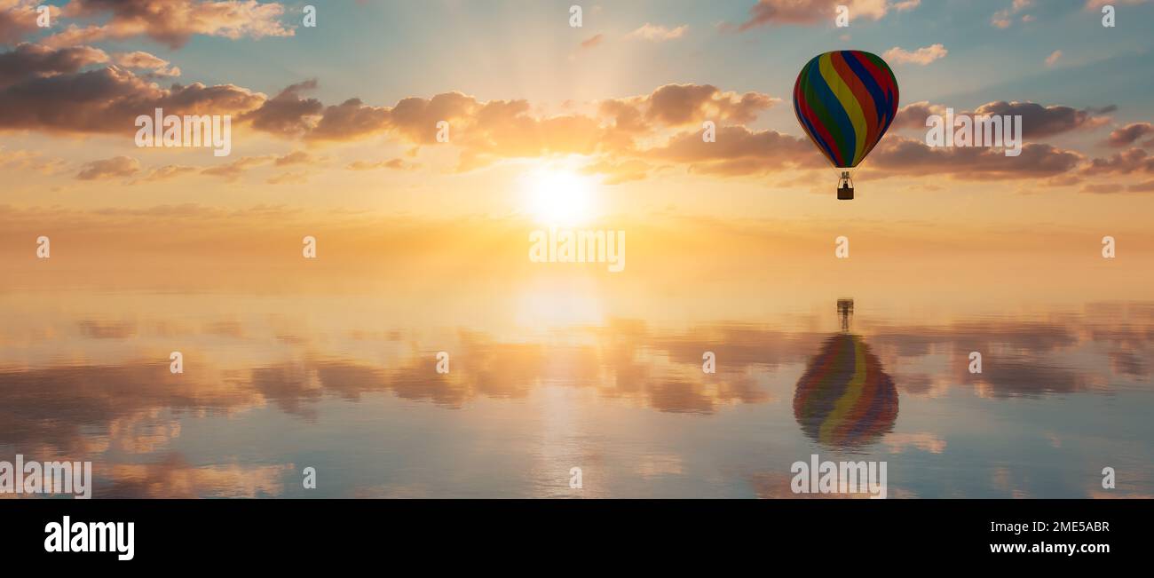 Hot Air Balloon Flying over the Calm Water. Dramatic Sunset Sky Stock ...