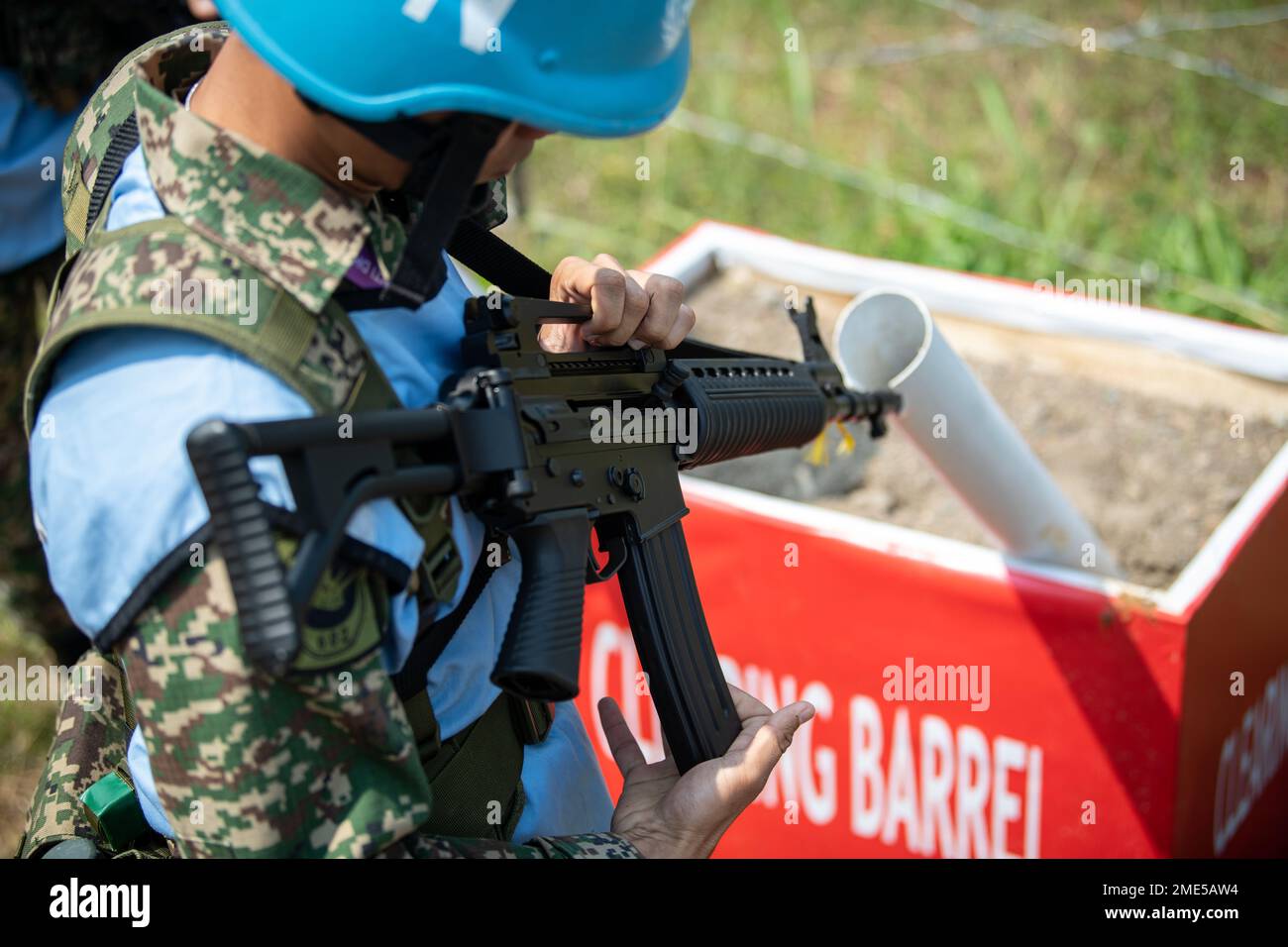 A soldier with the Malaysian Army loads a magazine into his rifle while ...