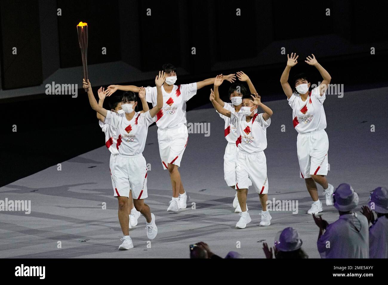 Torch bearers pass the Olympic flame during the opening ceremony in the ...