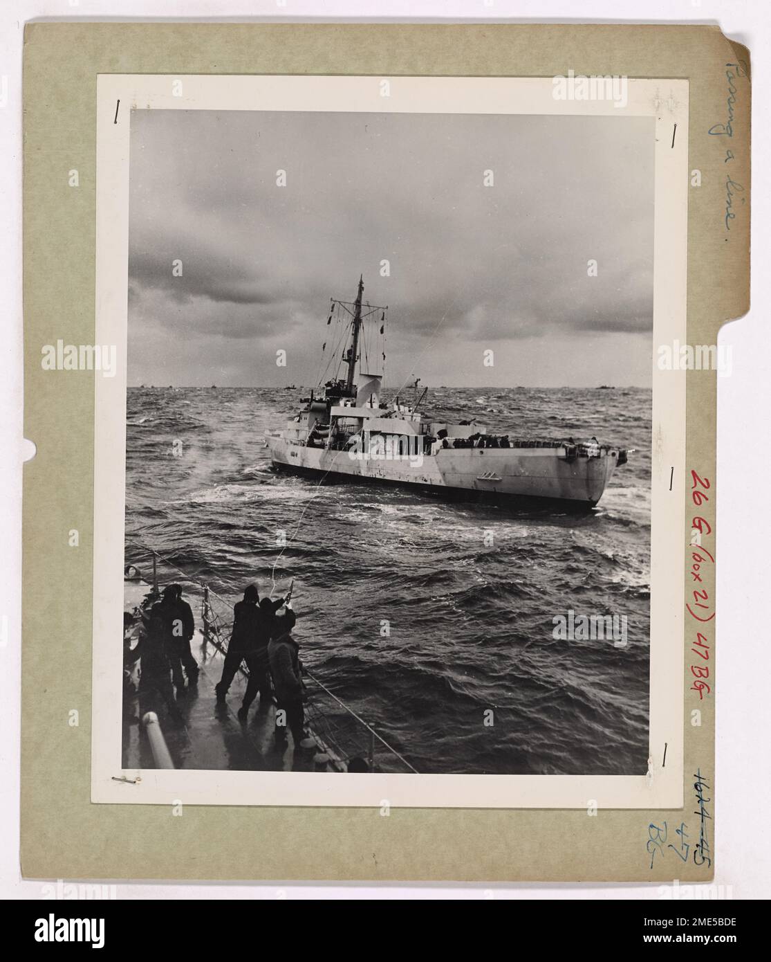 A Coast Guard combat cutter passes a line across its deck in the Mid ...