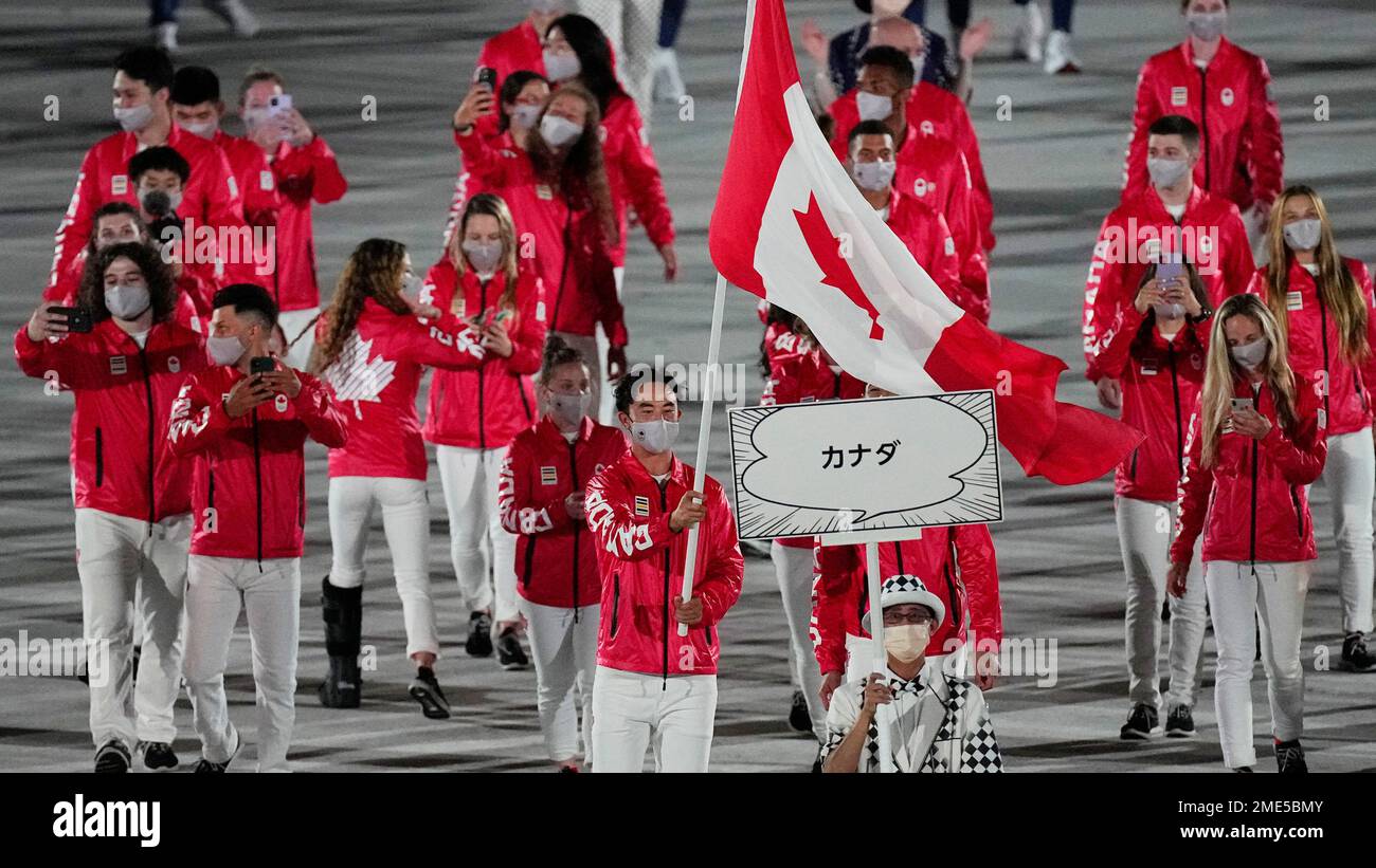 Miranda Ayim and Nathan Hirayama, of Canada, carry their country's flag ...