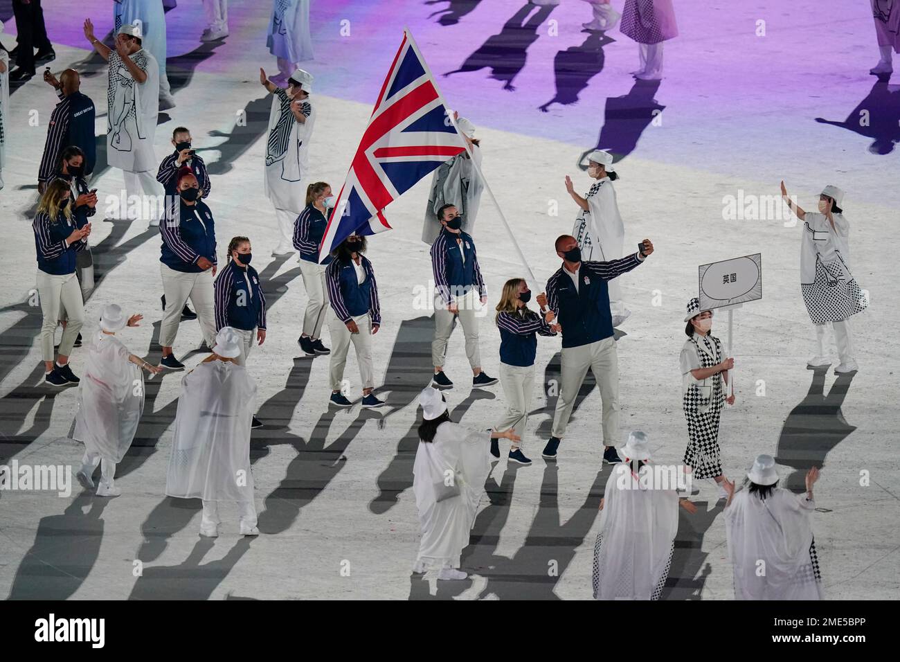 Hannah Mills and Mohamed Sbihi, of Britain, carry their country's flag ...