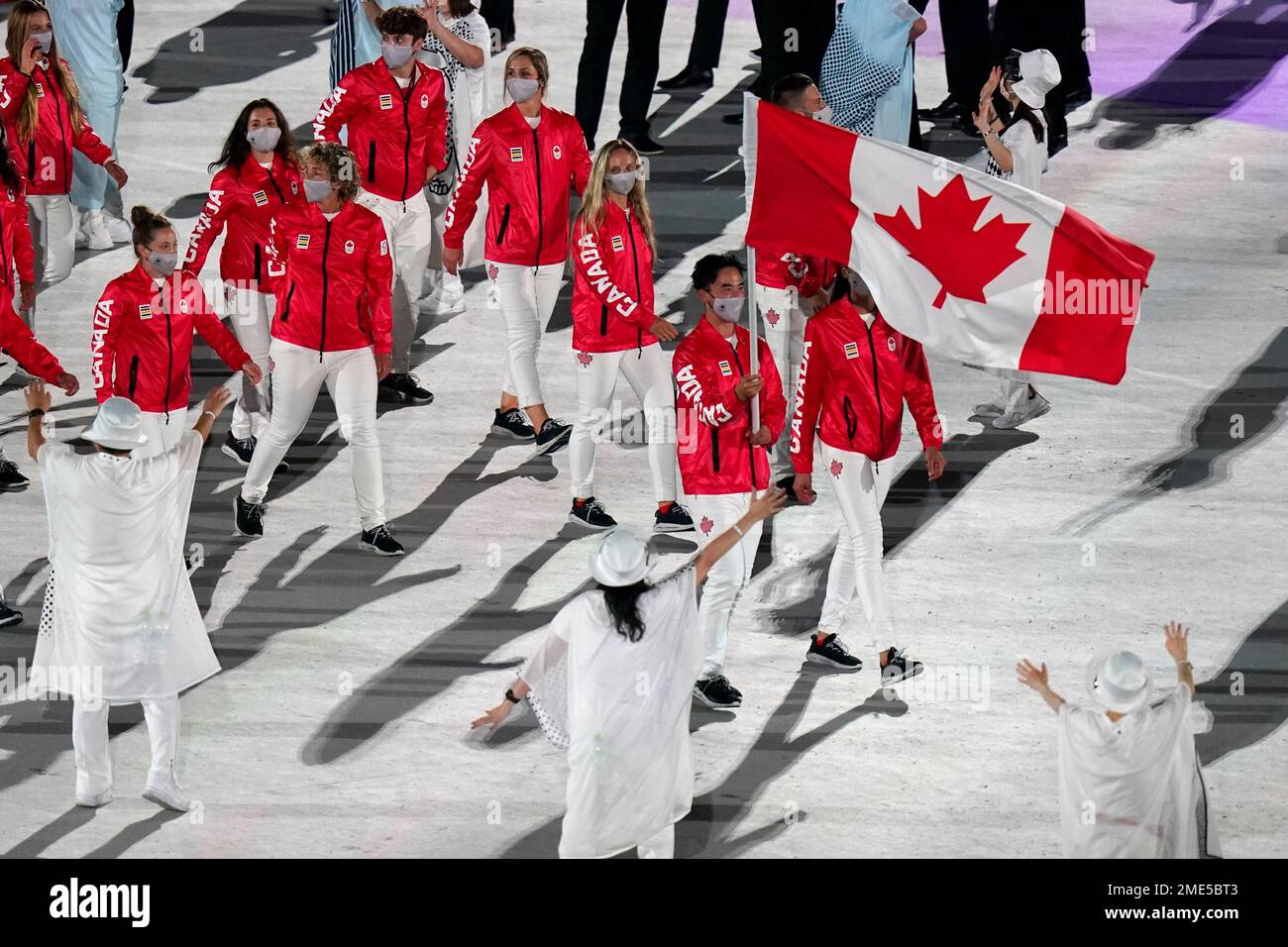 Miranda Ayim and Nathan Hirayama, of Canada, carry their country's flag ...
