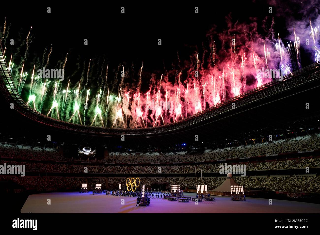 Fireworks explode from the roof of the stadium as the Olympic rings are ...