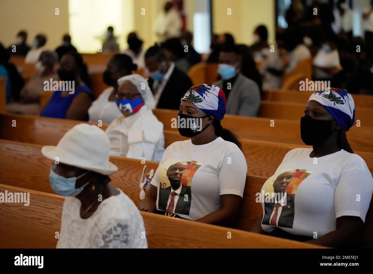 Women wear Haitian flag scarves and tee-shirts with an image of Haiti's ...