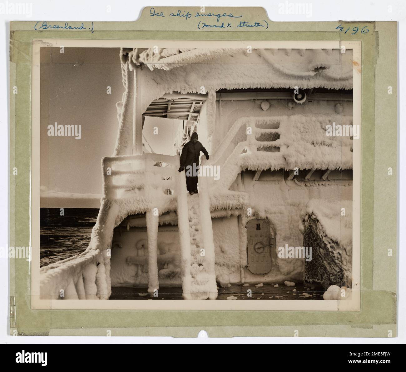 Coast Guardsman Howard K. Streeter carefully descends an iced-up ladder ...