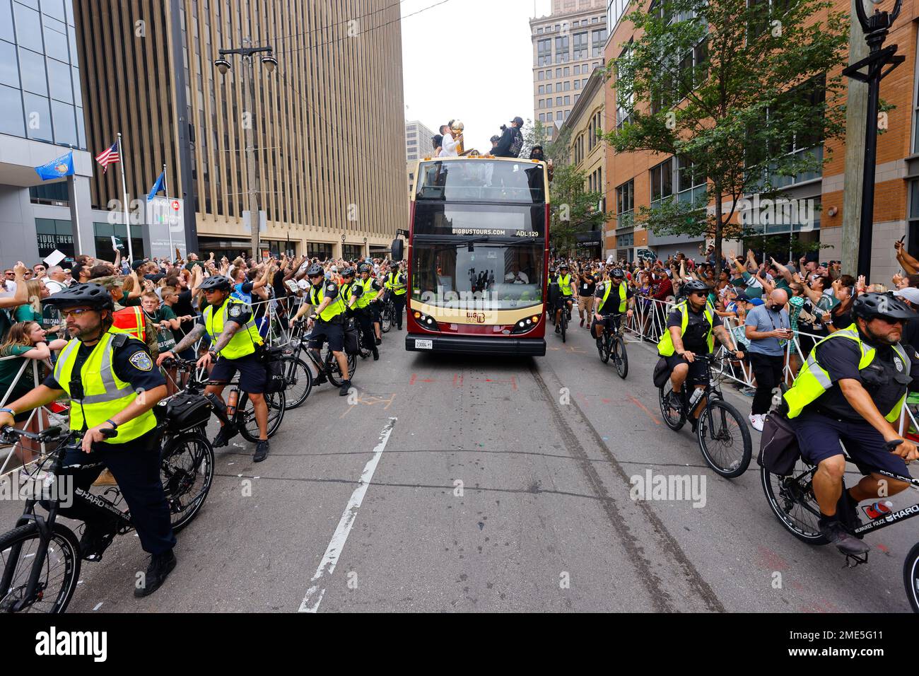 Police lead buses of players and staff during a parade for the NBA ...