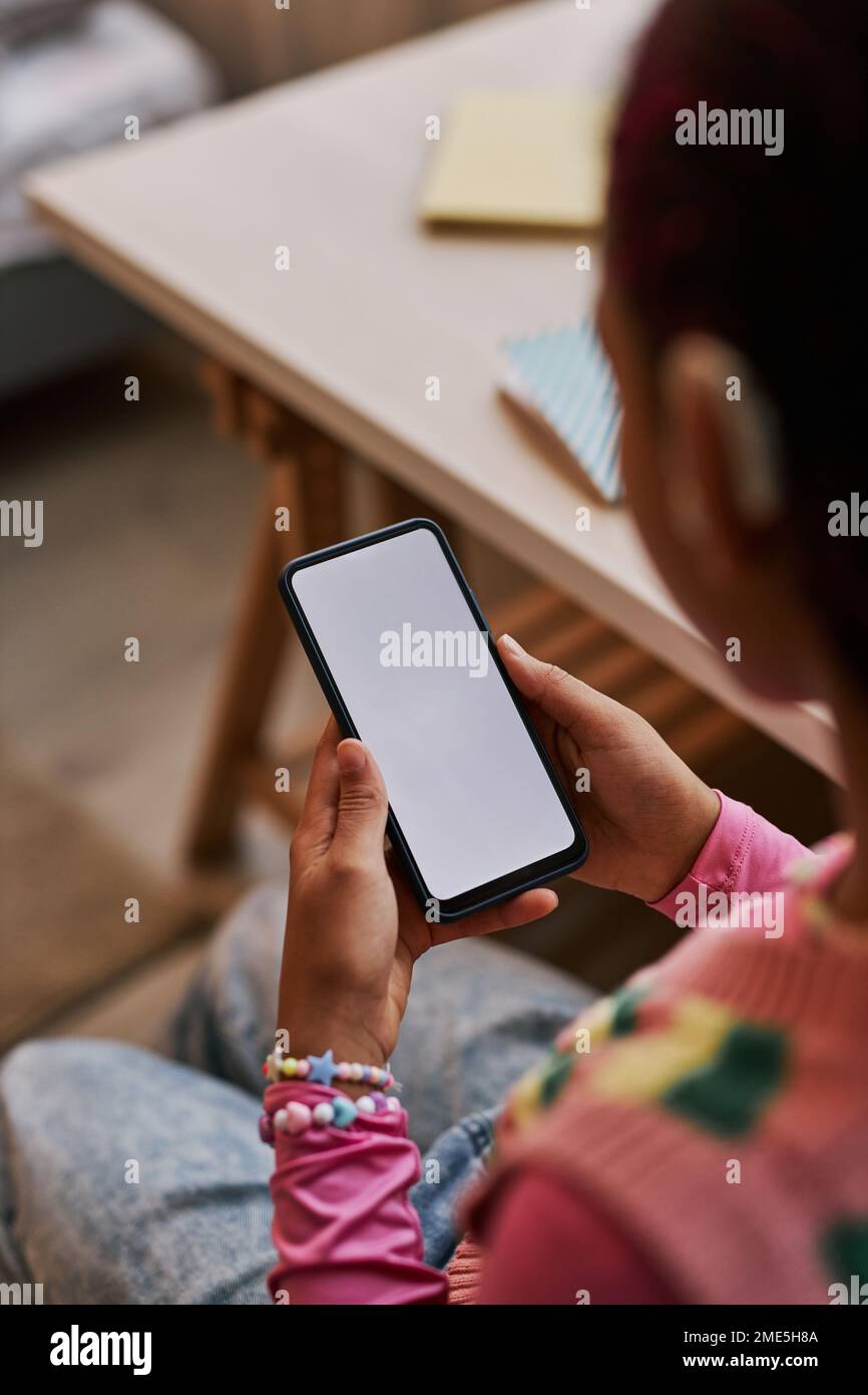 Vertical closeup of black teenage girl using smartphone with white ...