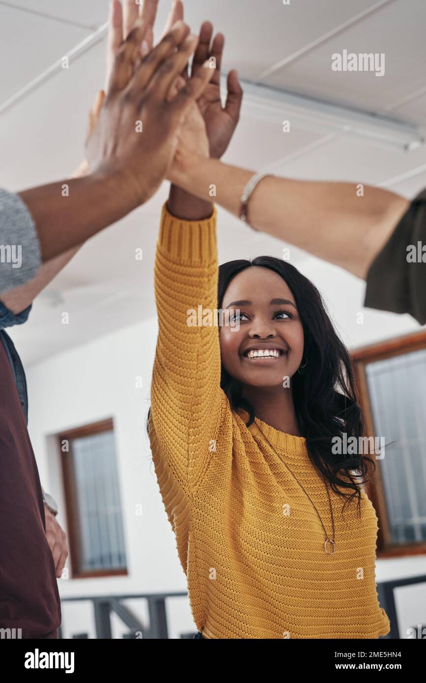Reaching new heights together. an attractive young businesswoman joining hands for a high five ...