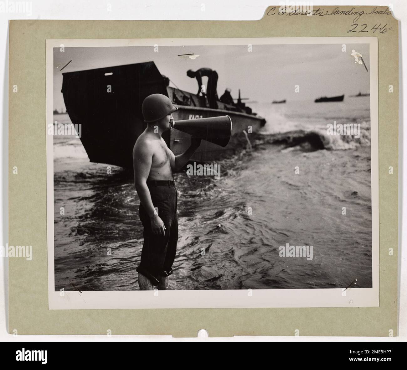 Coast Guardsman John C. Marco directs landing boats with supplies after ...