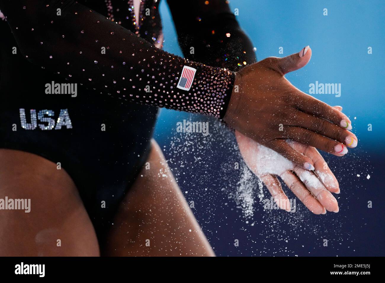 Simone Biles of the United States chalks her hands while training on ...