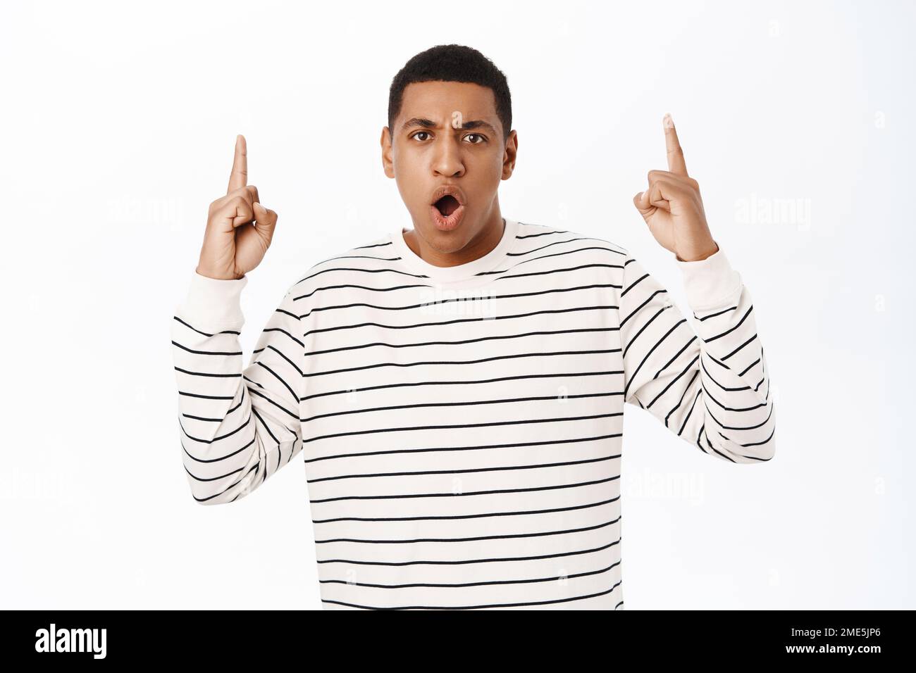 Shocked african american man, looking offended and pointing fingers up ...