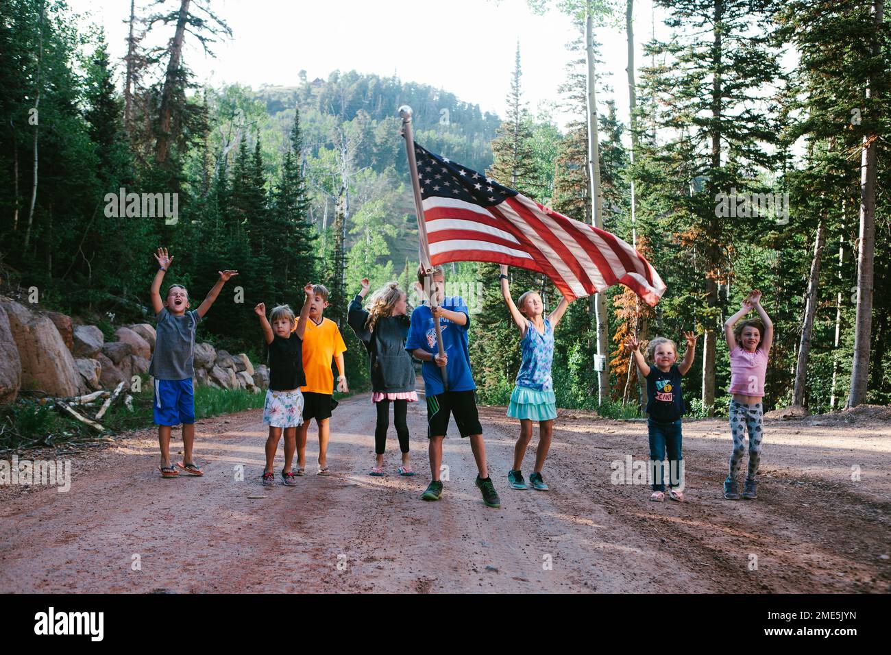 Cousins and kids cheer with happiness with American flag Stock Photo ...