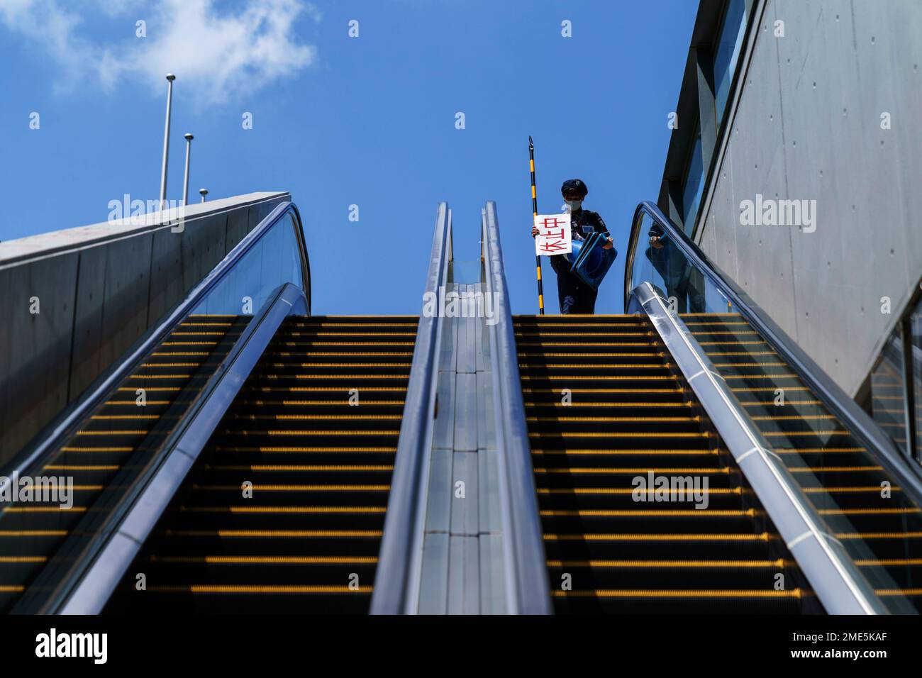 A worker removes cones to open an escalator for service outside the ...