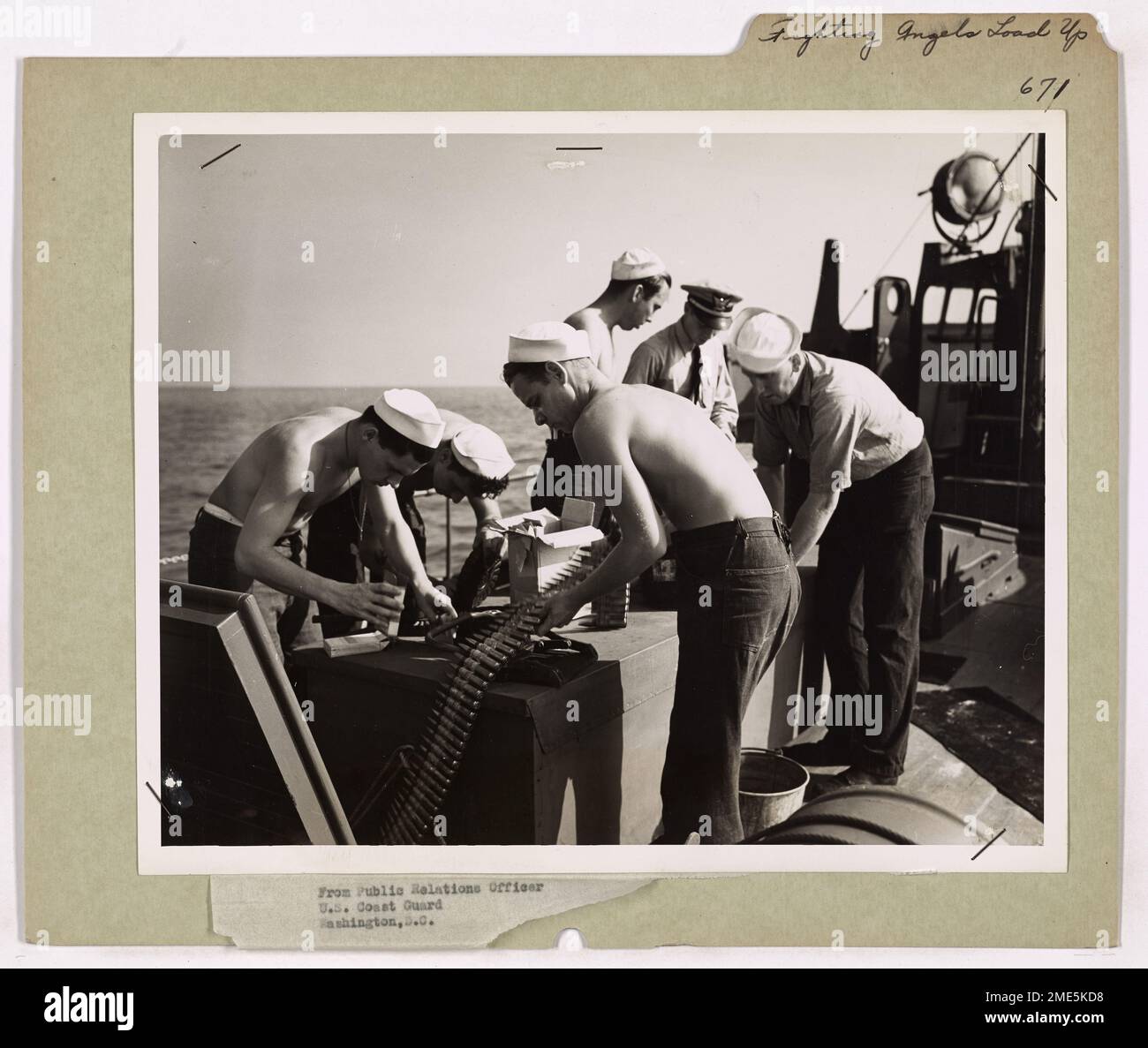 Coast Guardsmen are shown loading bullets into bandoliers, preparing ...