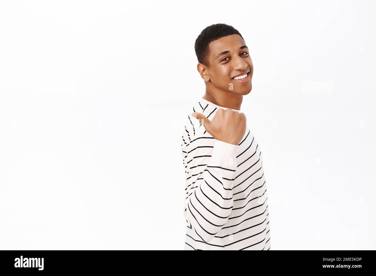 Smiling african american man pointing behind his back, showing product ...