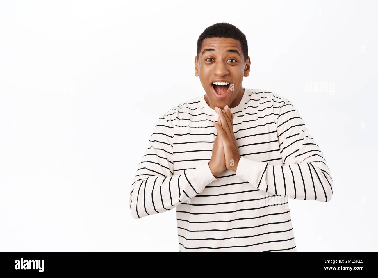 Smiling Black man looking thankful, shows namaste, appreciation gesture ...