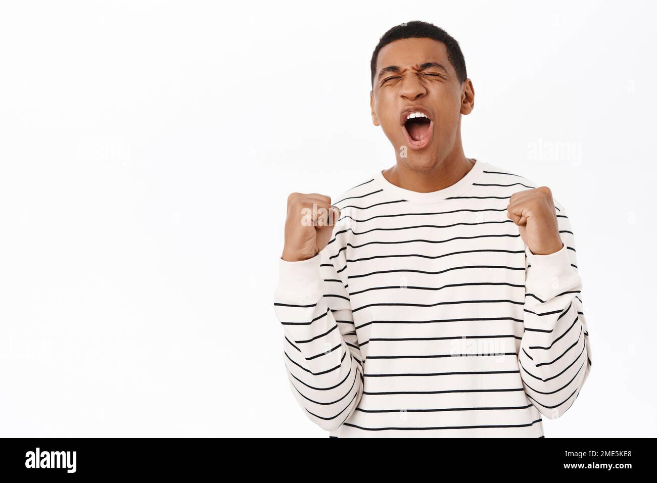 Enthusiastic african american man winning, triumphing, celebrating ...