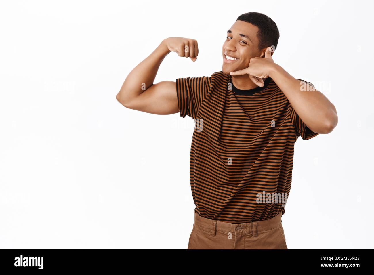 Sport and gym concept. Strong African american man flex biceps, shows ...