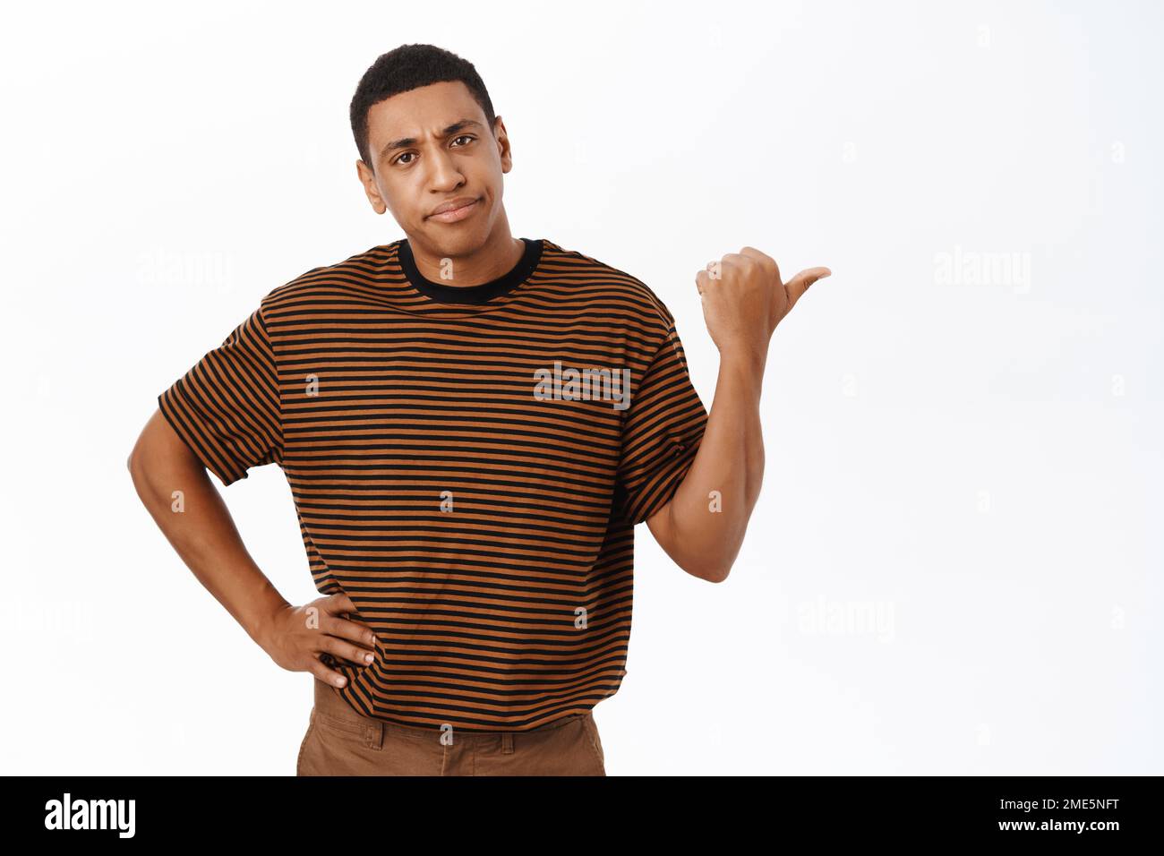 Upset african american man pointing finger right, frowning disappointed ...