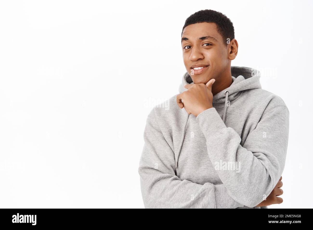 Smiling african american man looking with interest at camera, thinking ...