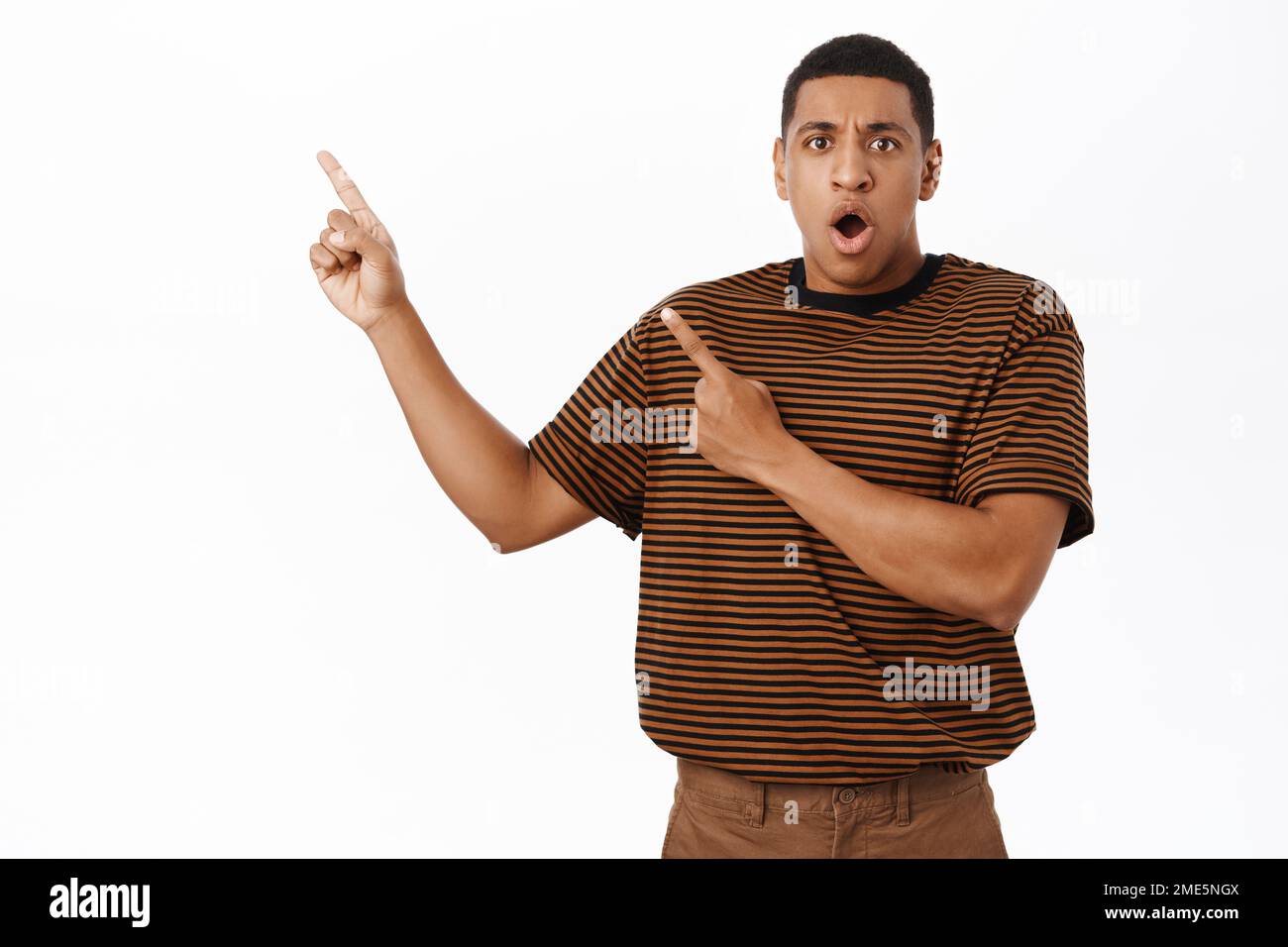 Portrait of disappointed african american man pointing finger left ...