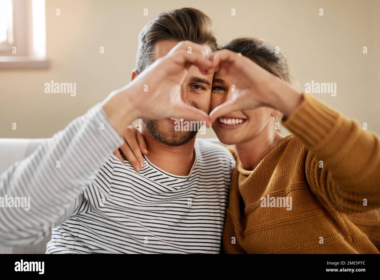 Love brought us together. a couple forming a heart shape with their ...