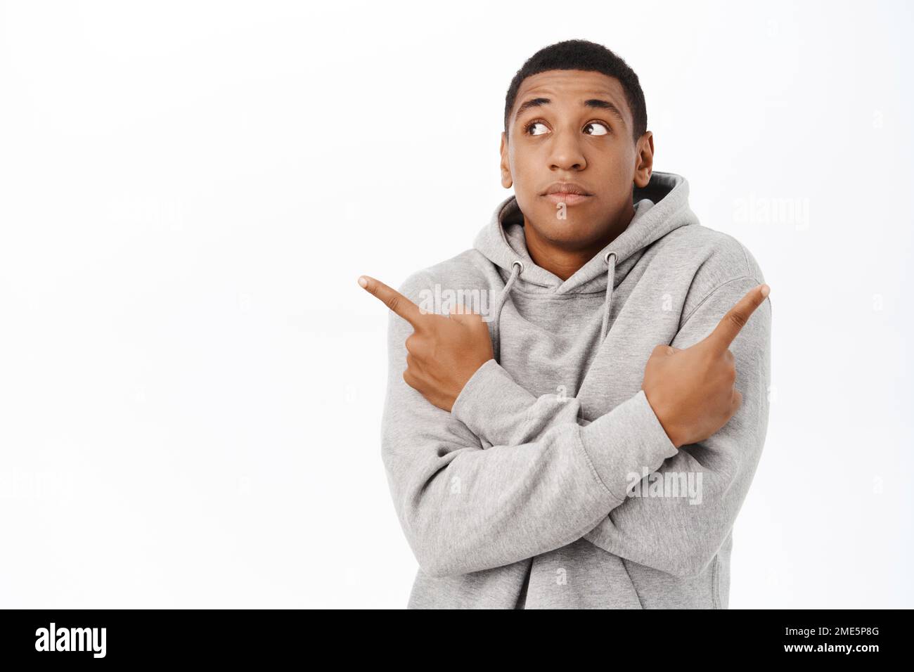 Portait of man pointing in different directions with confused face ...