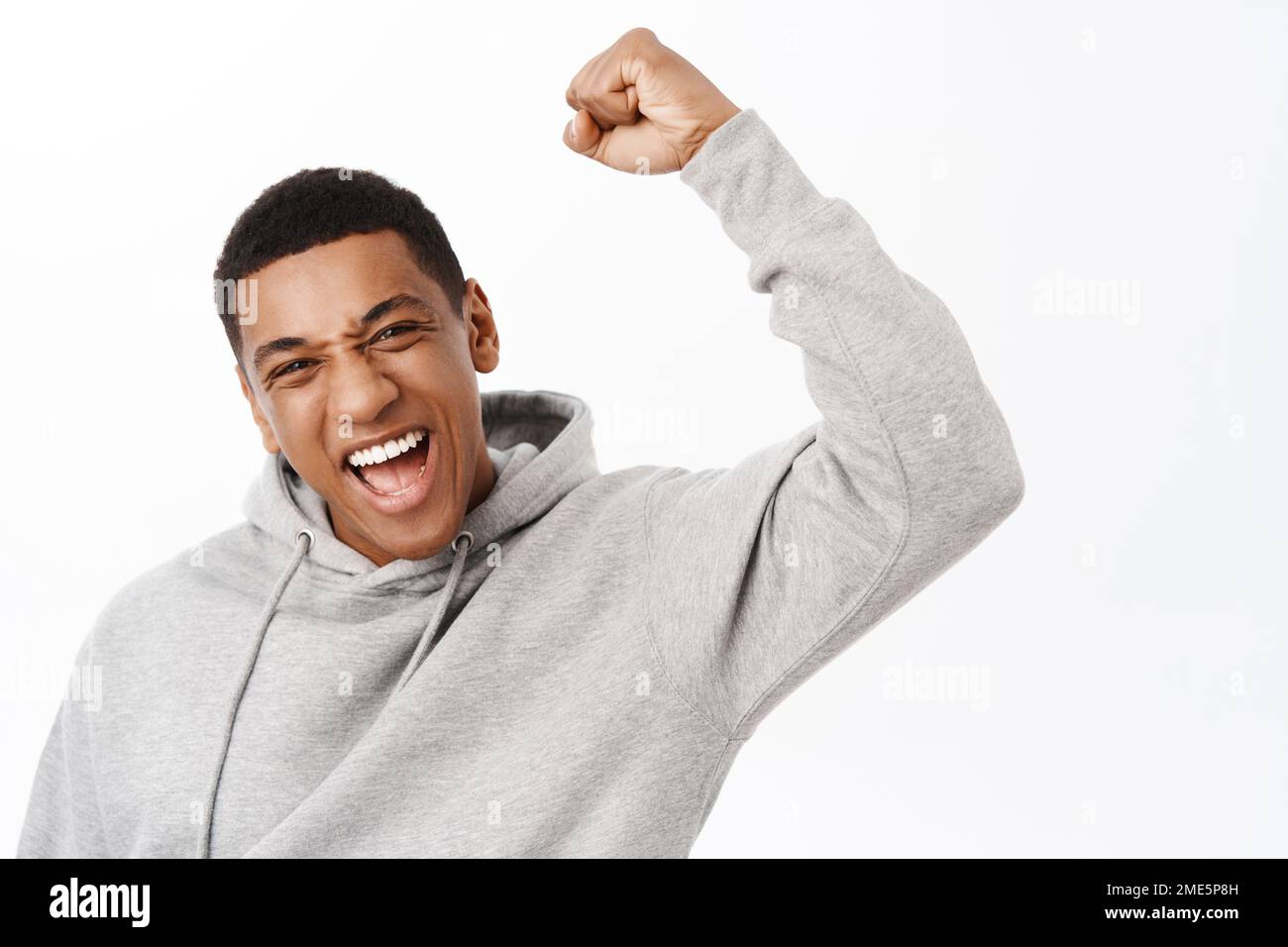 Winner. Enthusiastic African american man celebrating, raising fist up ...