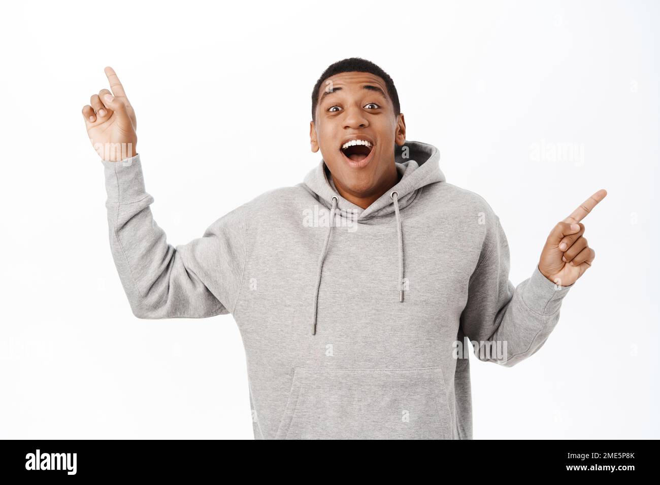 Happy smiling african american man pointing fingers sideways, showing ...