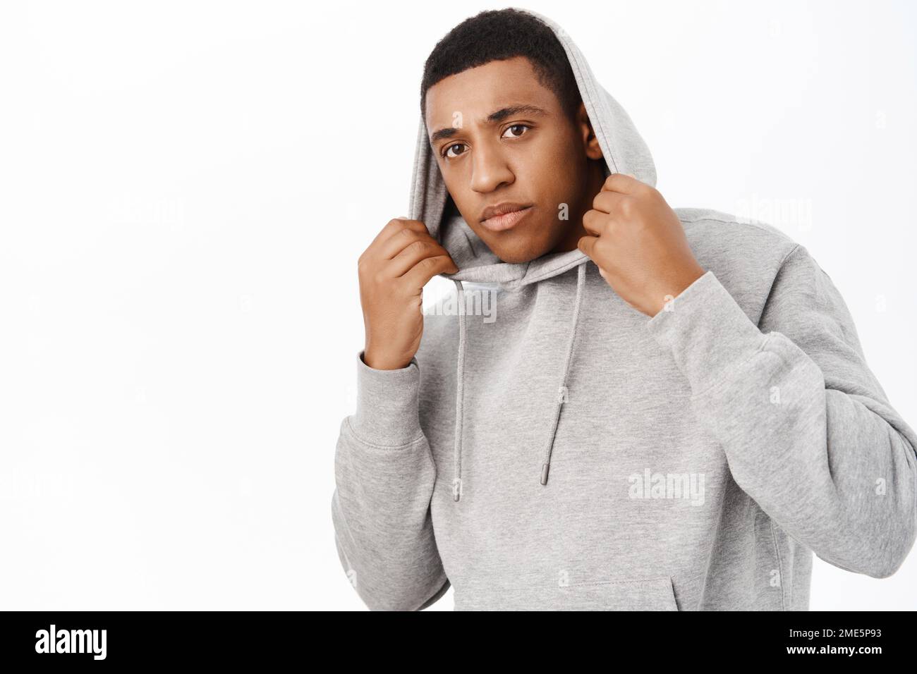 Portrait of confident, handsome african american man, pull hoodie on ...