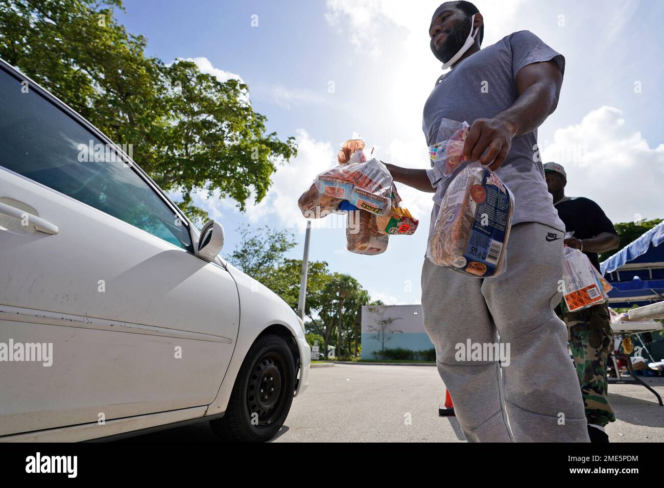 Wesner Louis, with the Miami Rescue Mission, loads bread products into ...
