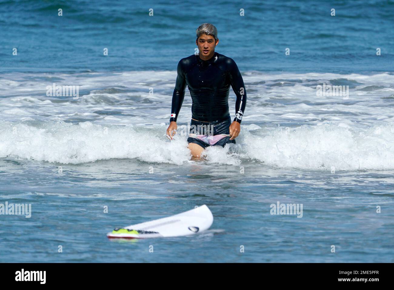Surfer Kanoa Igarashi, of Japan, walks toward his board during a ...