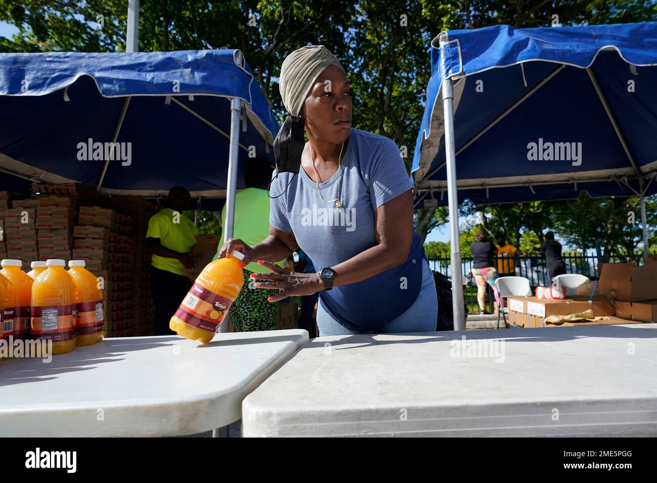 Gwen Chestnut stocks bottles of orange juice during a food distribution ...