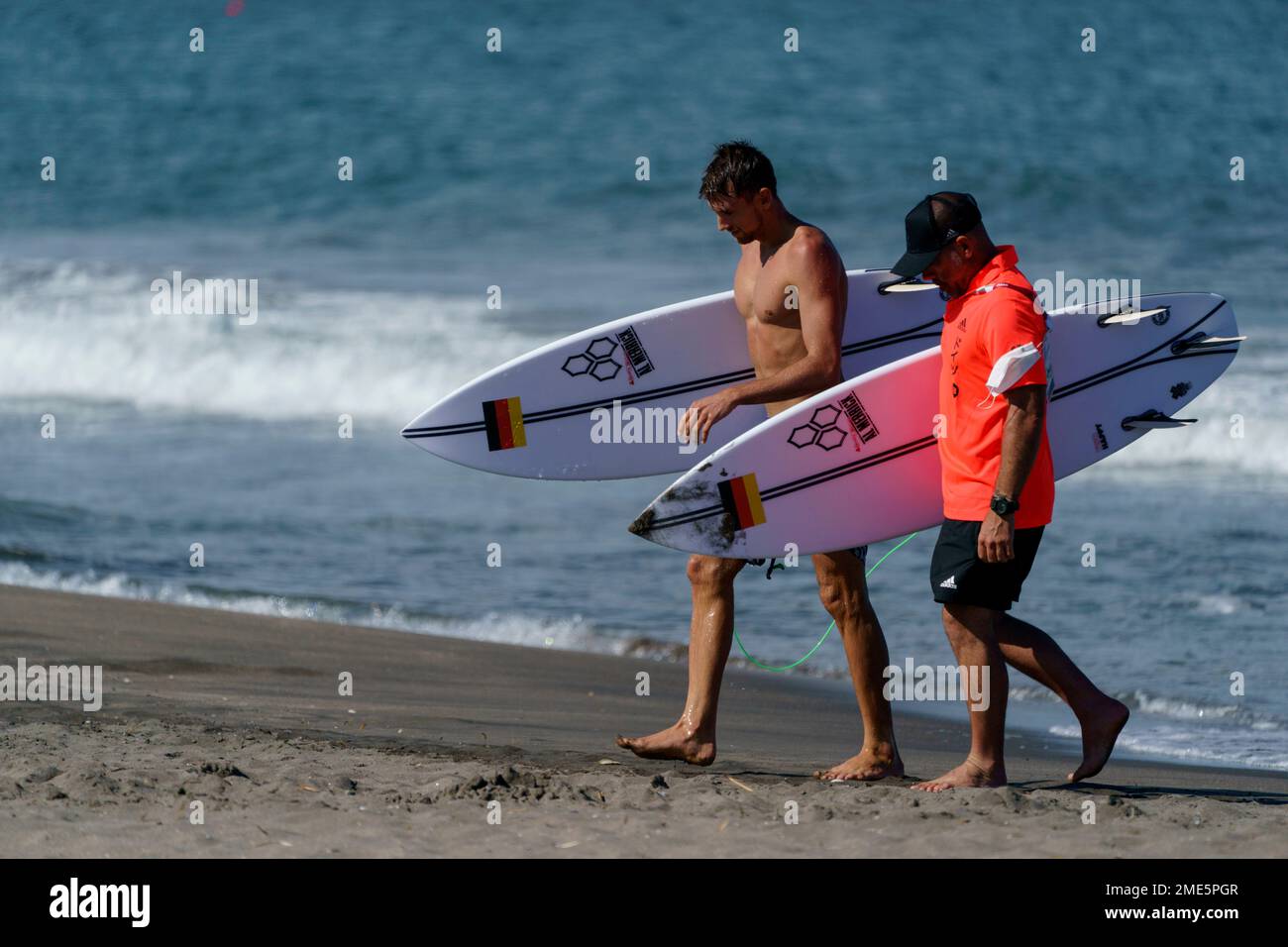 Surfer Leon Glatzer, of Germany, left, walks with his coach, Llewellyn ...