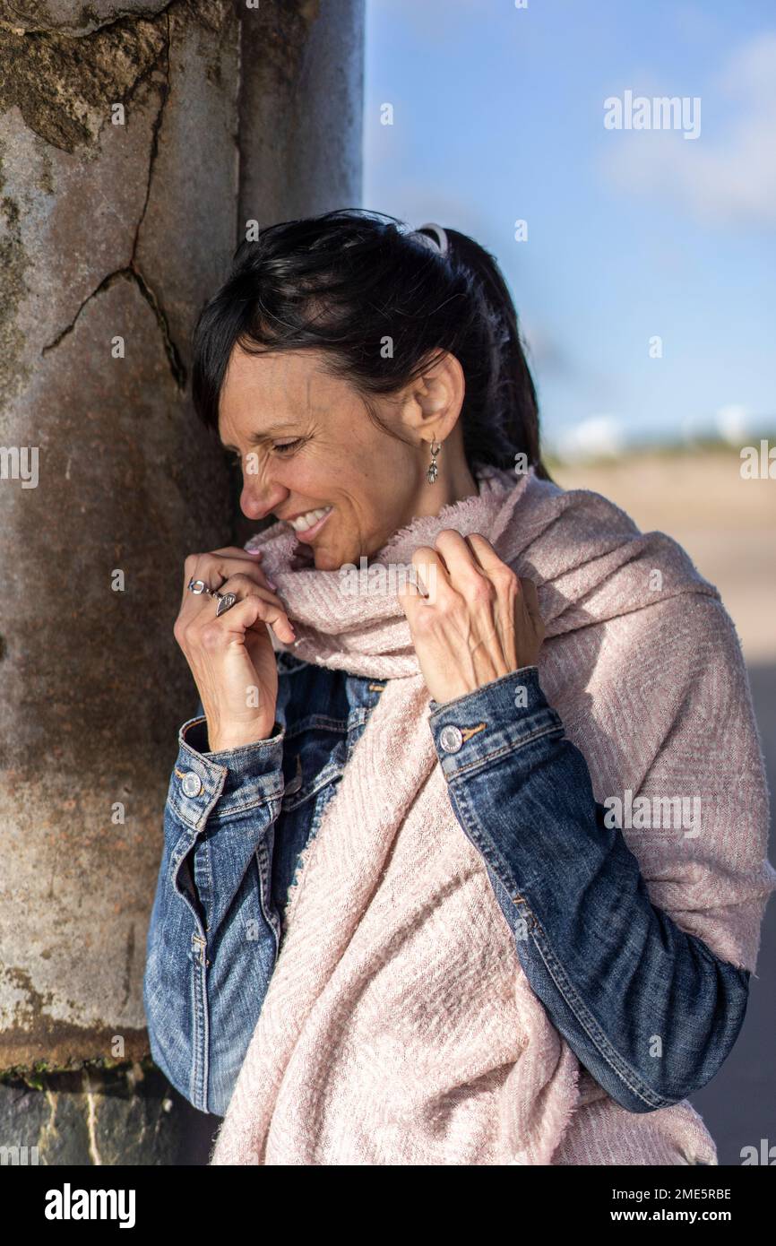 Portrait of a woman leaning on a pillar Stock Photo - Alamy