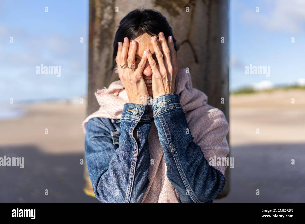 Portrait of a laughing woman covering her face with her hands Stock ...