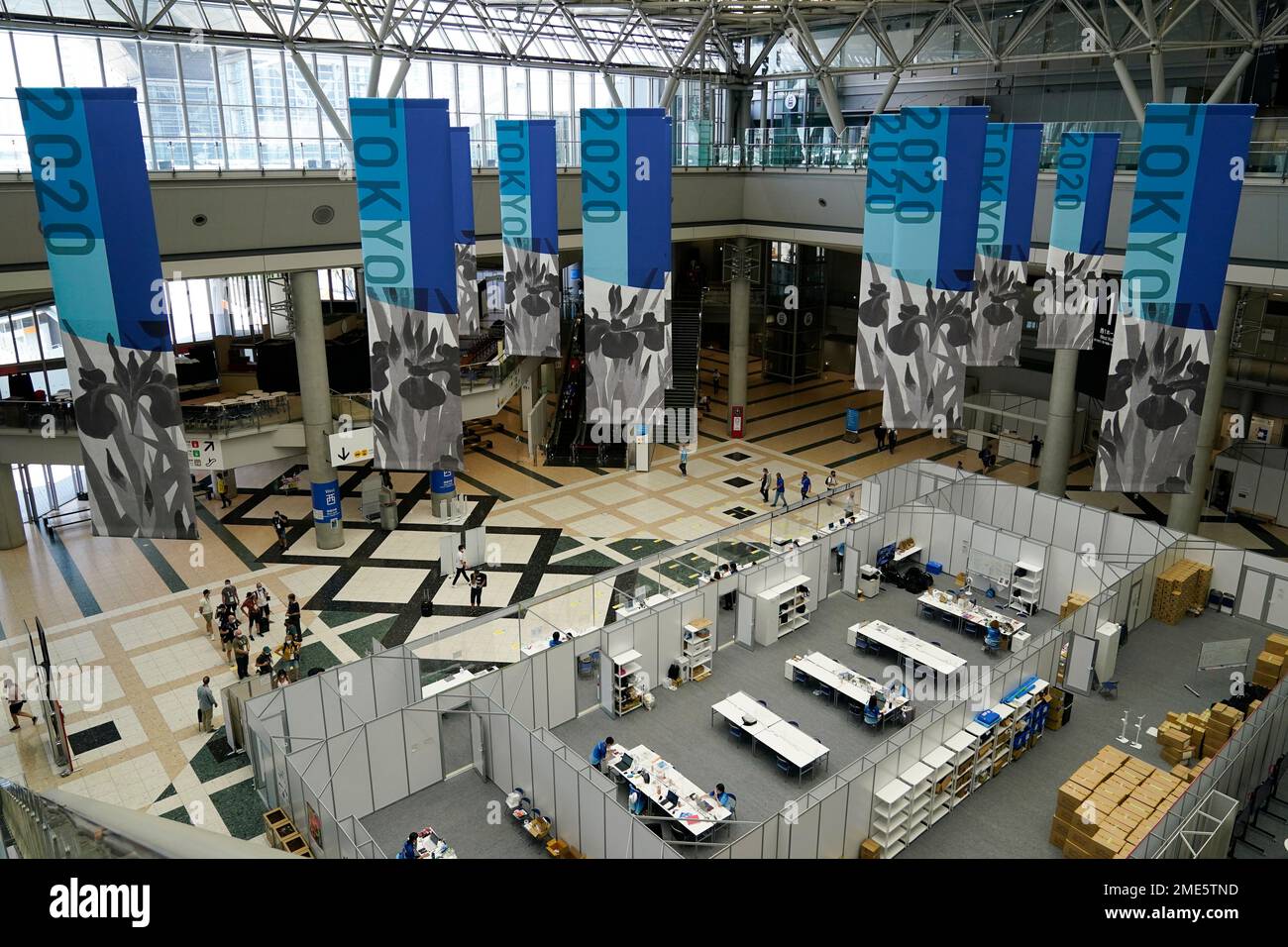 People walk around the Main Press Center at the 2020 Summer Olympics ...