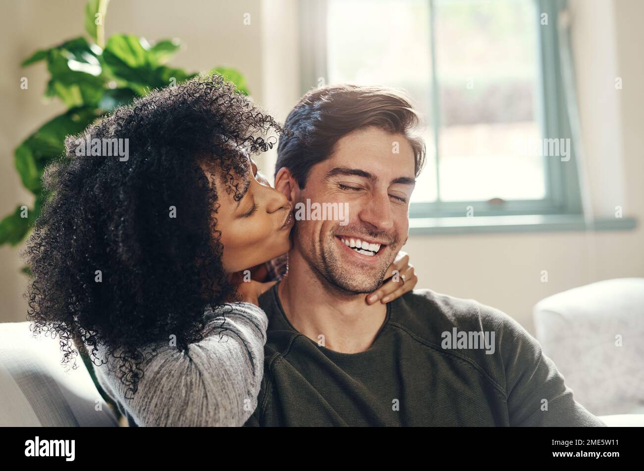 Our love grows stronger by the day. a young woman kissing her boyfriend ...