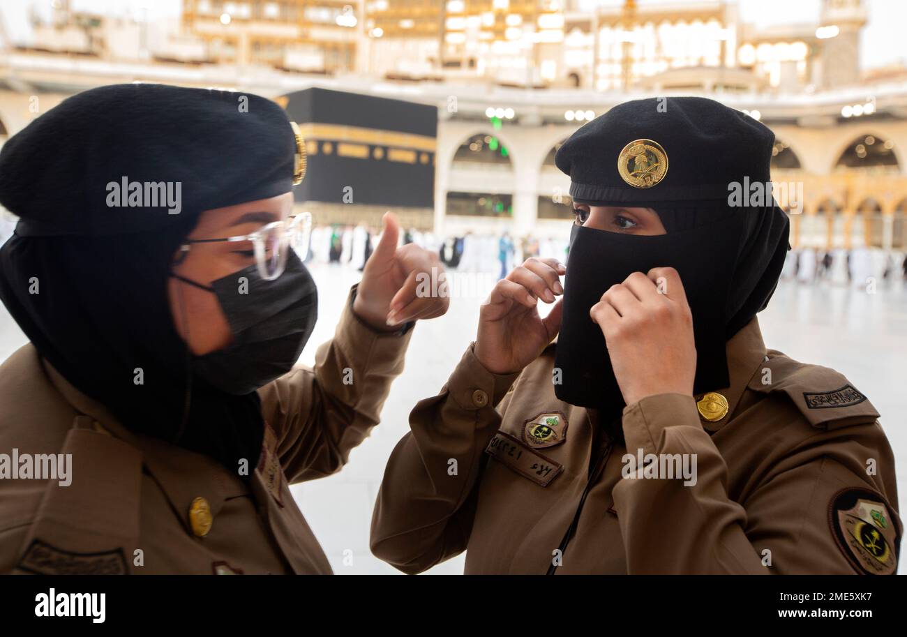 Saudi police woman, Bashair, left, adjusts the veil of her colleague ...