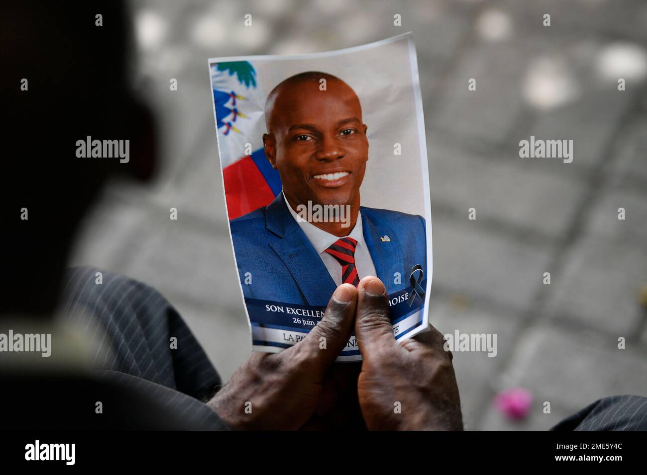 A person holds a photo of late Haitian President Jovenel Moise during ...