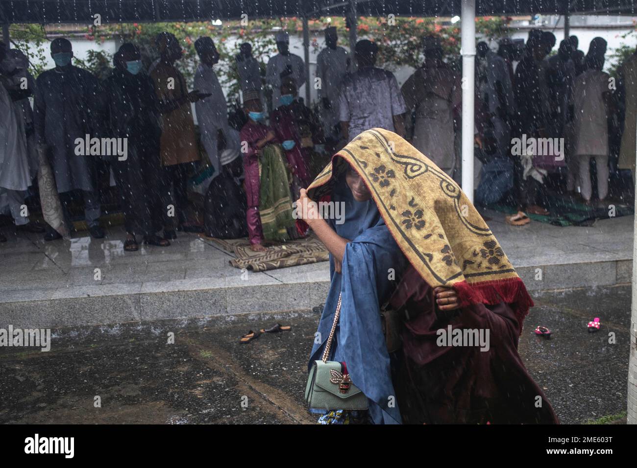 Muslims take shelter from the rain after performing Eid prayers in ...