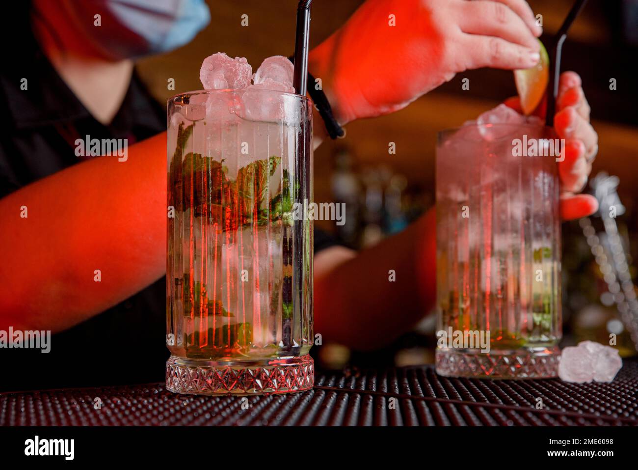 young woman bartender makes a cocktail with face mask Stock Photo - Alamy