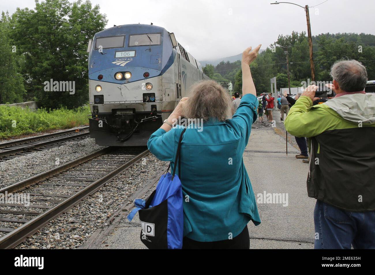 An onlooker waves as the Amtrak Vermonter passenger train arrives at ...