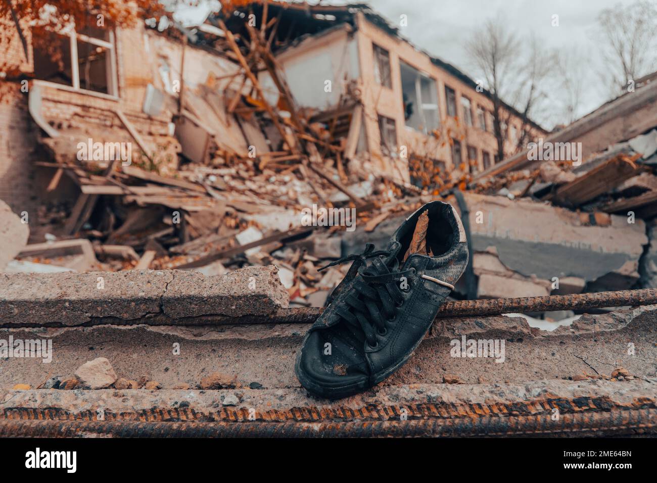 Blue shoe lies against the background of a destroyed house. War in ...