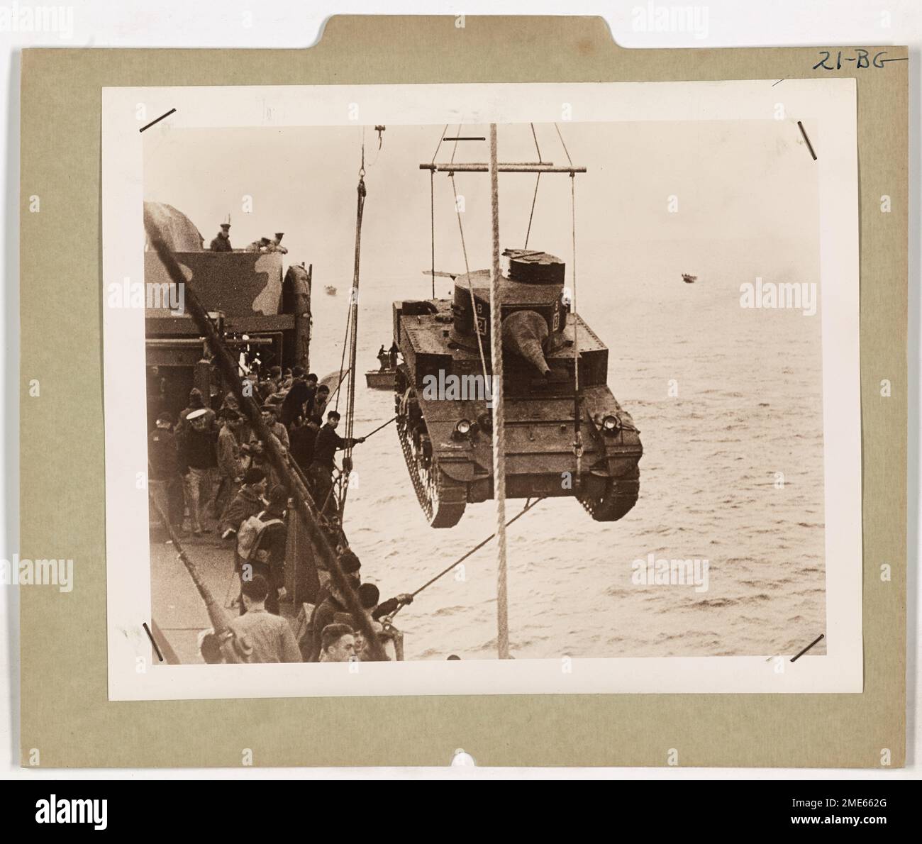 Coast Guardsmen move a tank aboard a boat while stationed in the ...